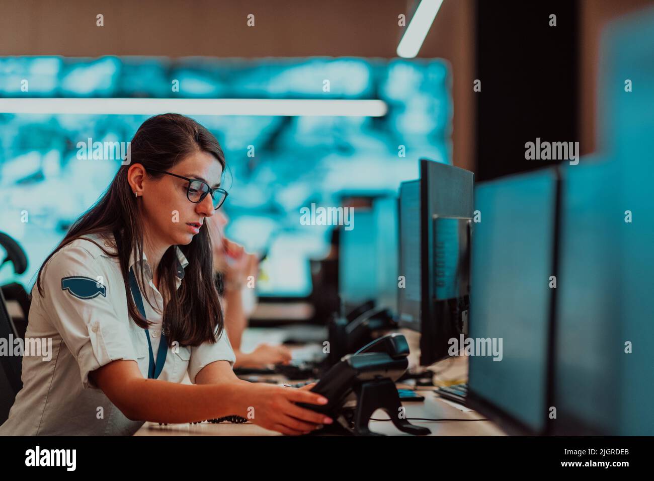 Female security operator working in a data system control room offices ...