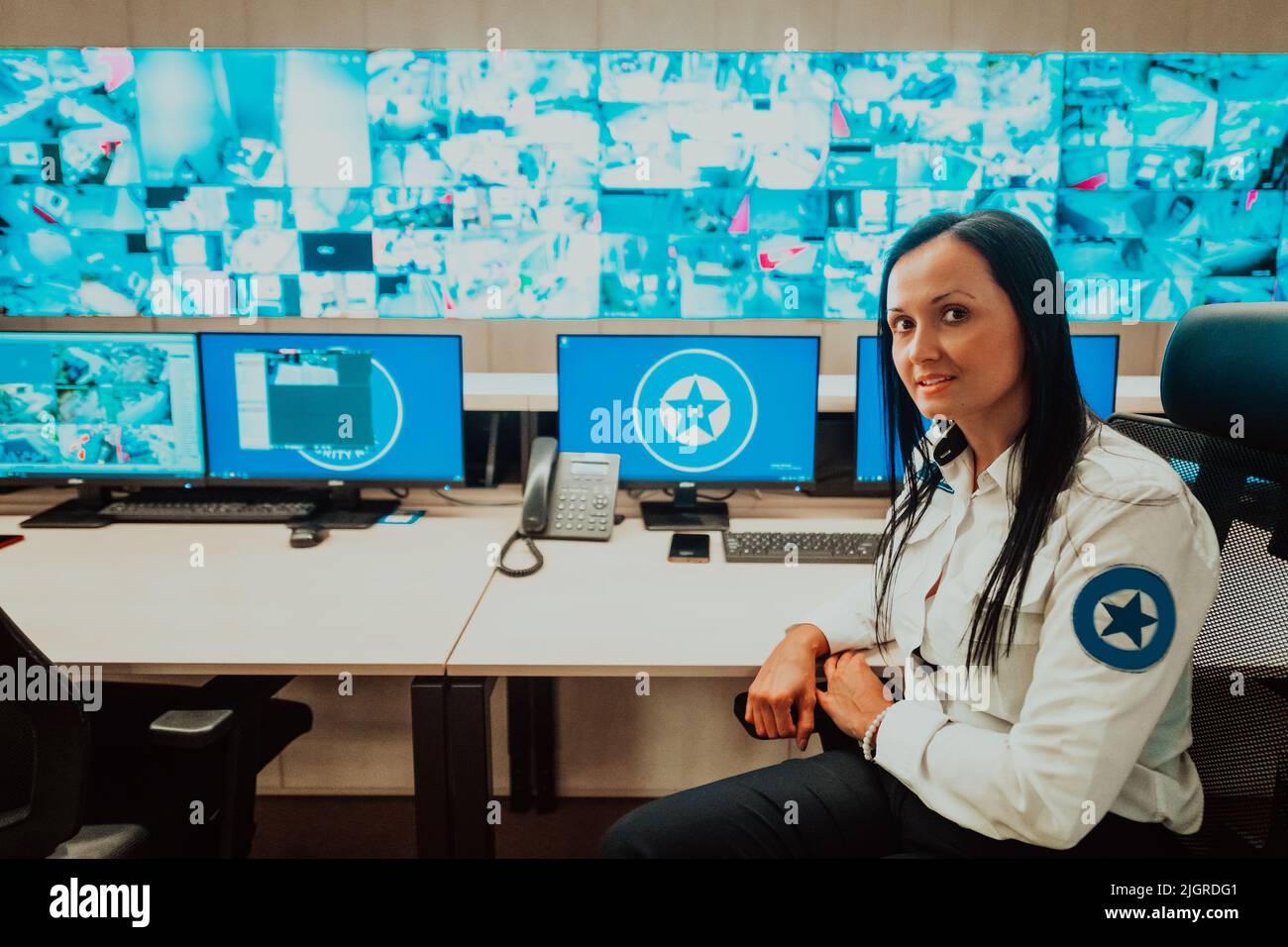Female security operator working in a data system control room offices ...