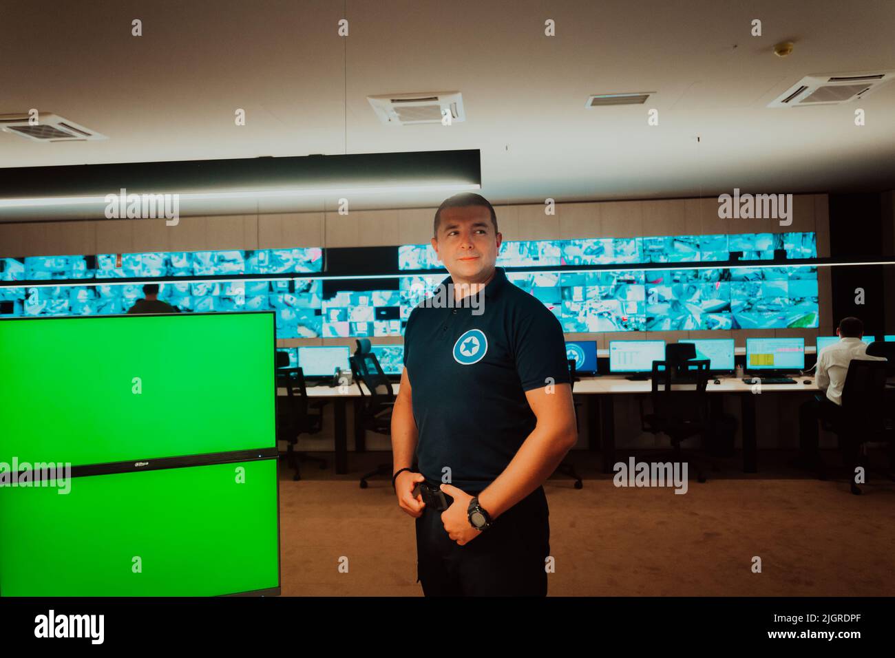 Male security operator working in a data system control room offices ...