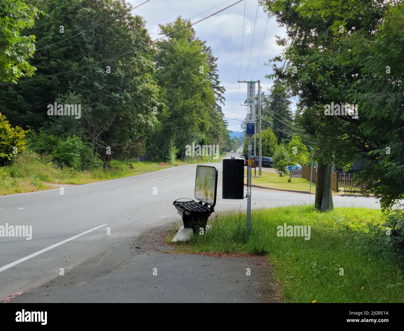 A bus stop on a road in summer Stock Photo - Alamy
