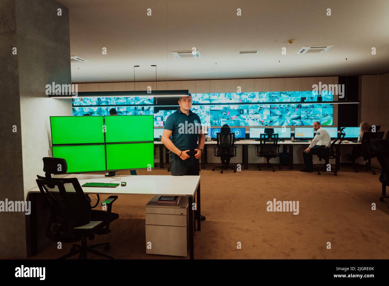Male security operator working in a data system control room offices ...