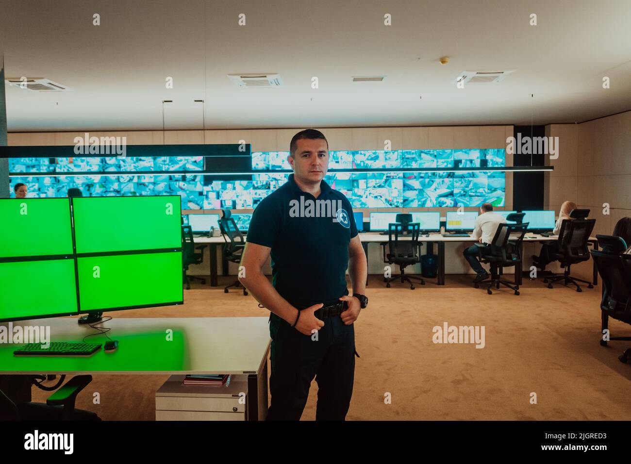 Male security operator working in a data system control room offices ...
