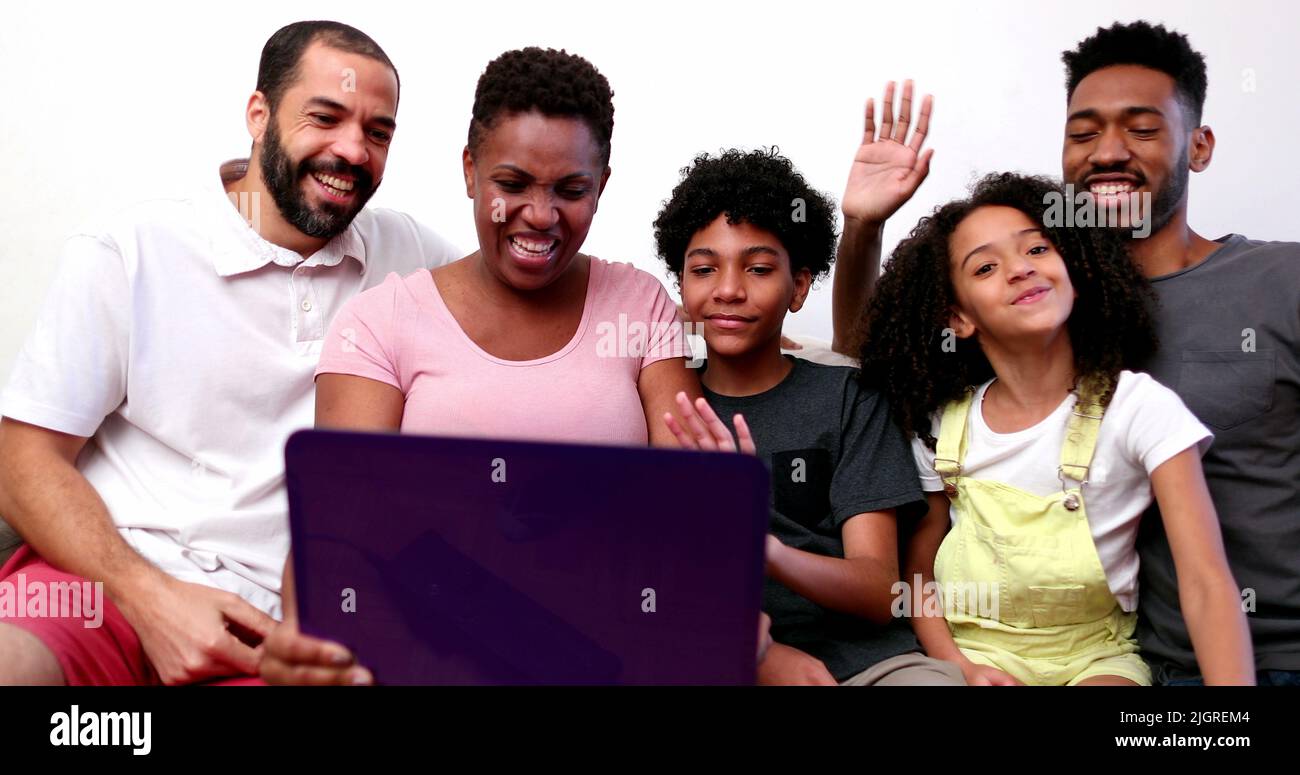 Black family waving hello or good bye to relative on video conference ...