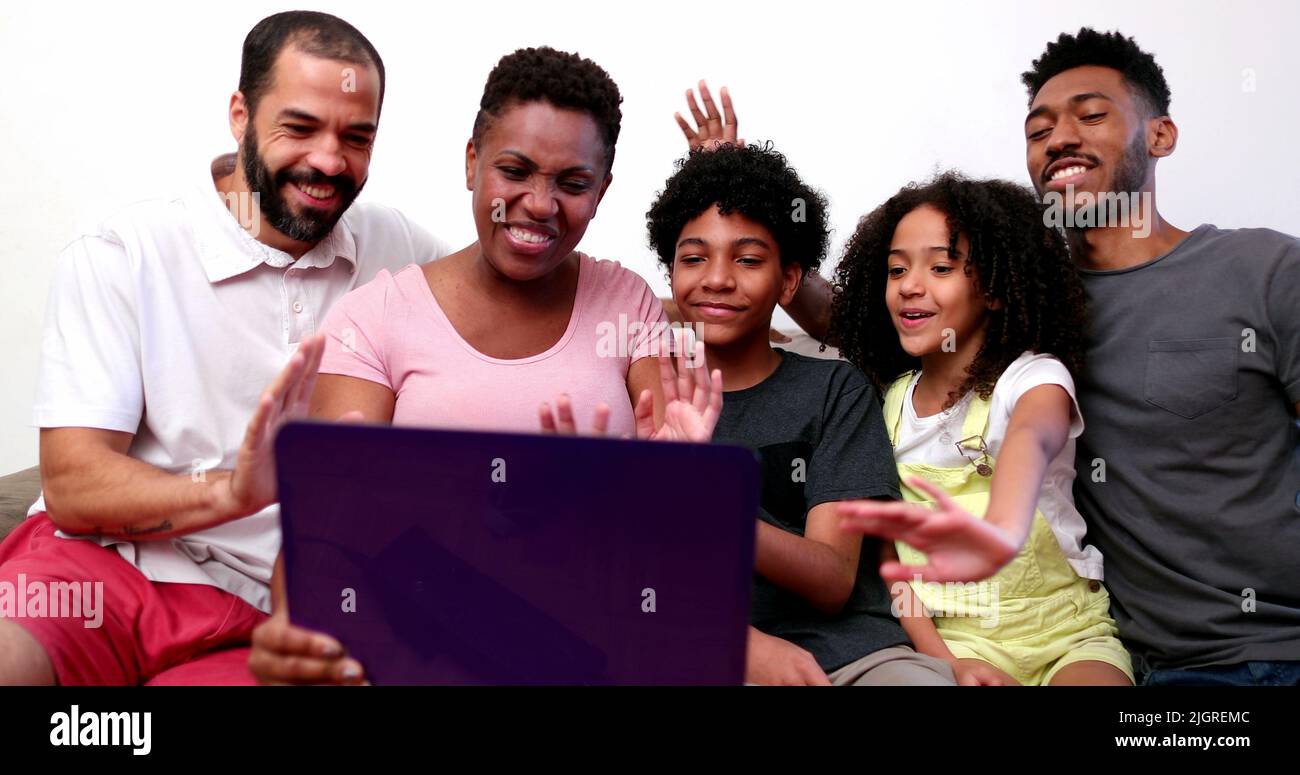 Black family waving hello or good bye to relative on video conference ...
