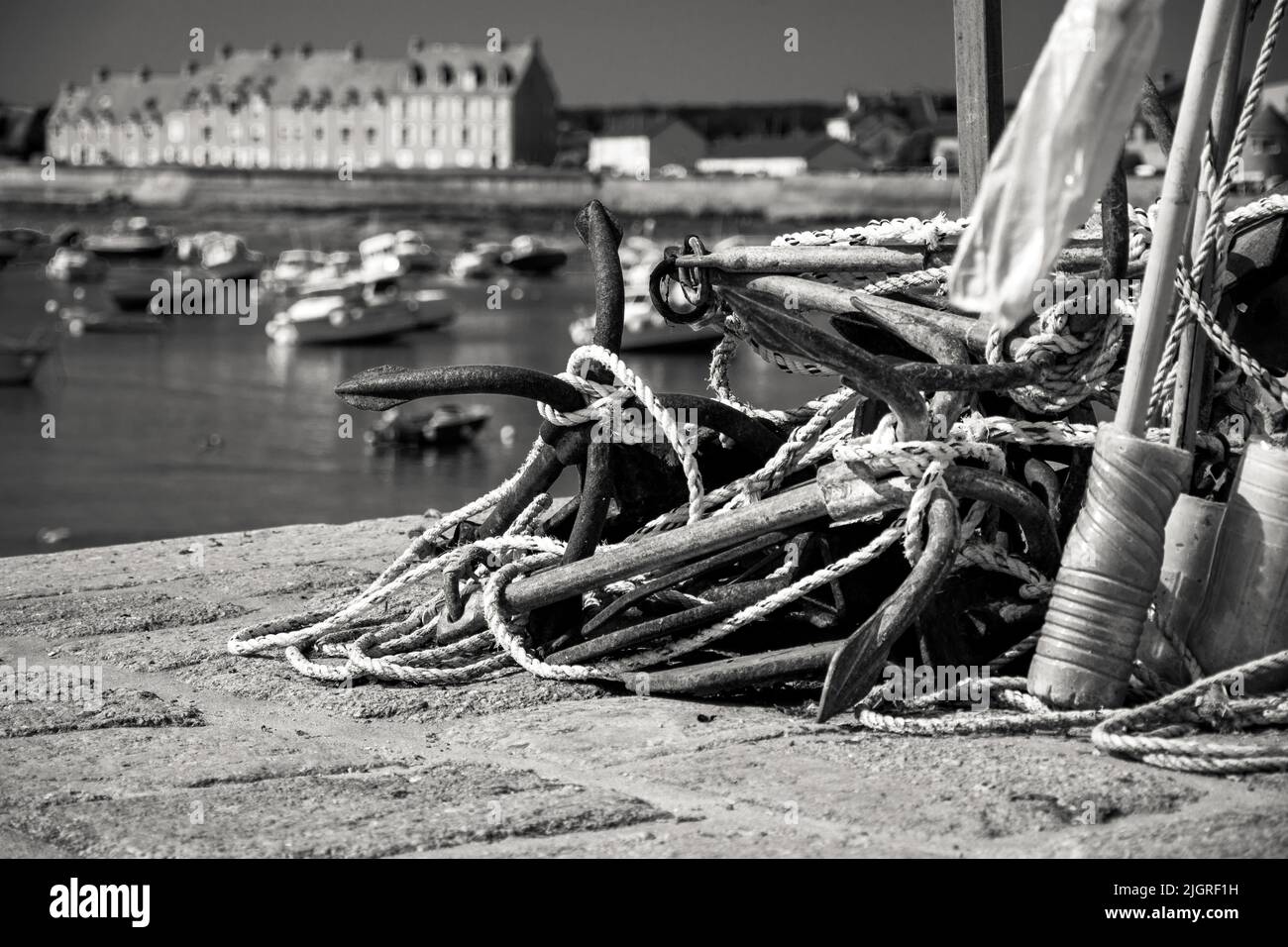 A grayscale shot of anchors and ropes on a docking station Stock Photo ...