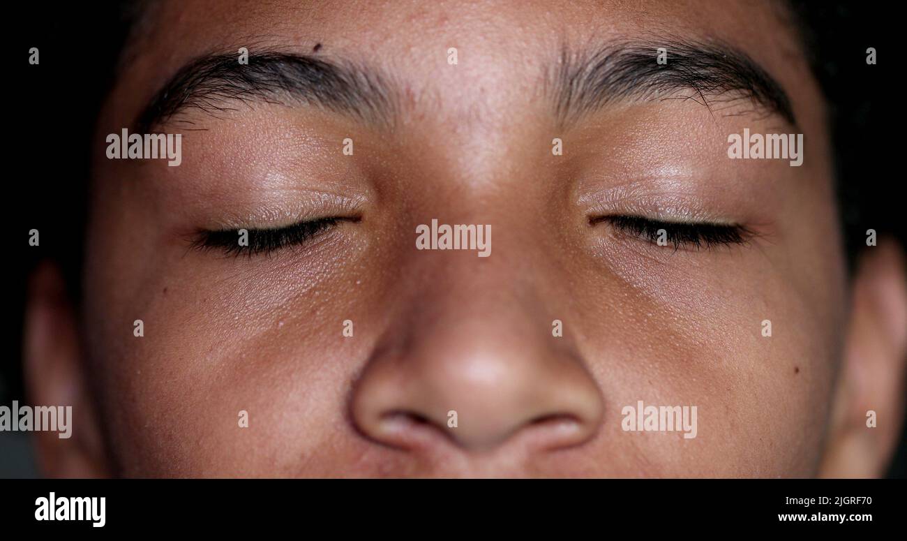 Child closing eyes taking a deep breath and smiling at camera. Macro ...