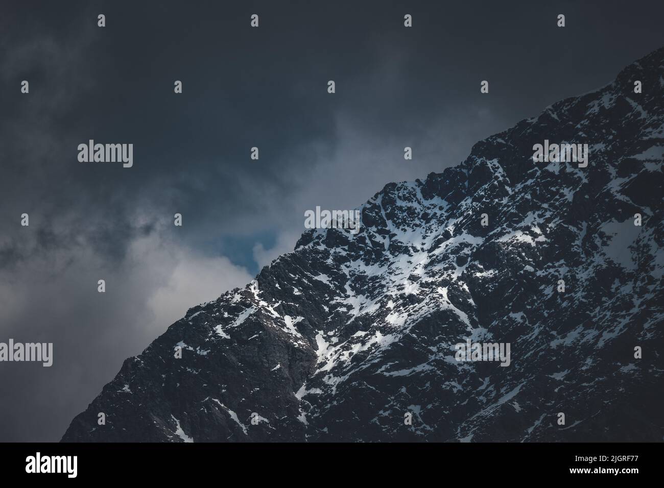 A scenic view of a mountain partially covered with snow under the ...