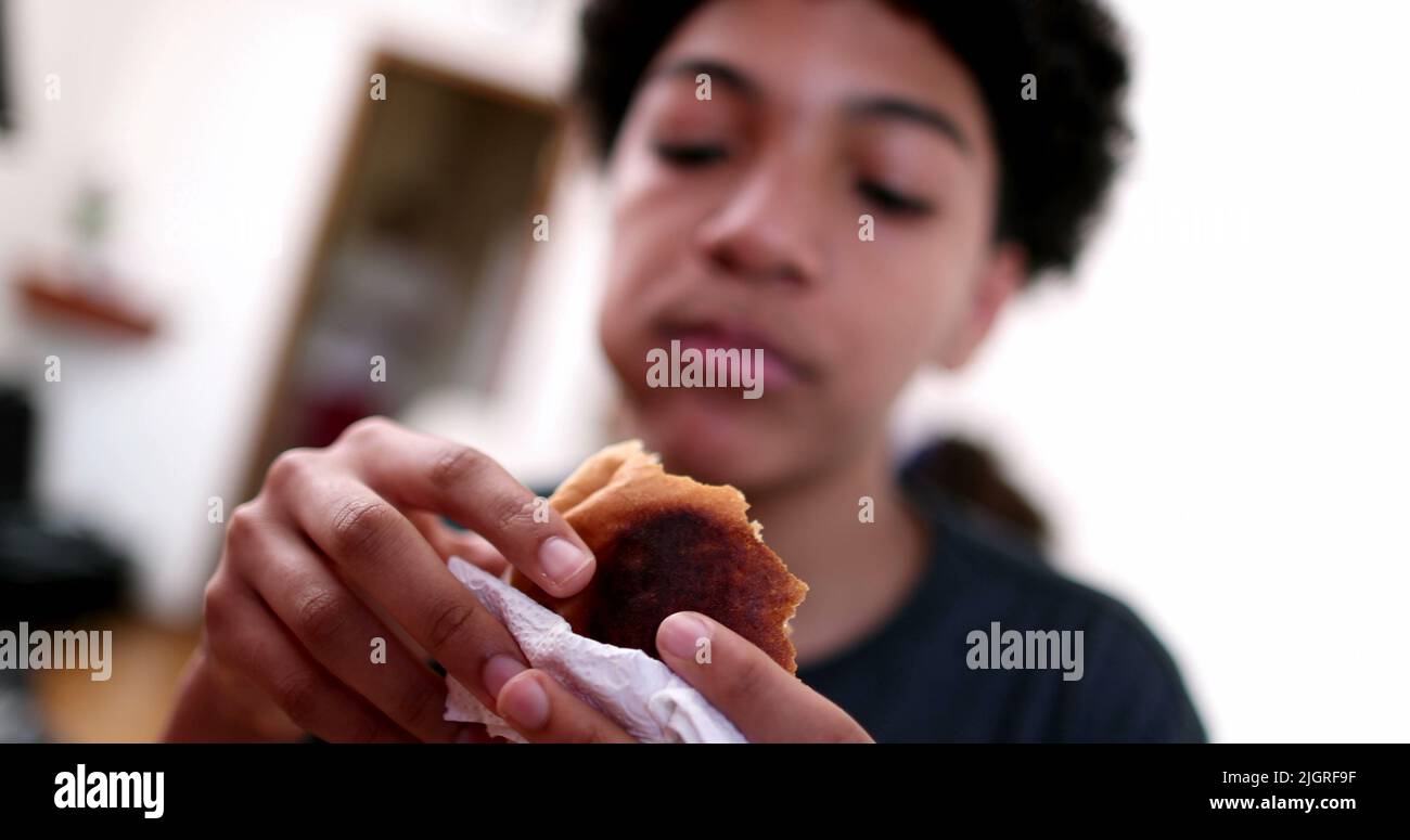 Child eating burger. Young boy taking a bite of hamburger Stock Photo ...