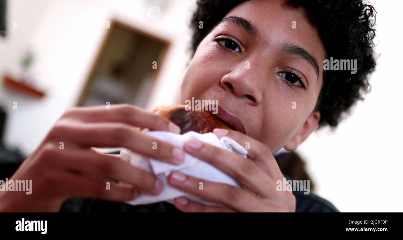 Child eating burger. Young boy taking a bite of hamburger Stock Photo ...