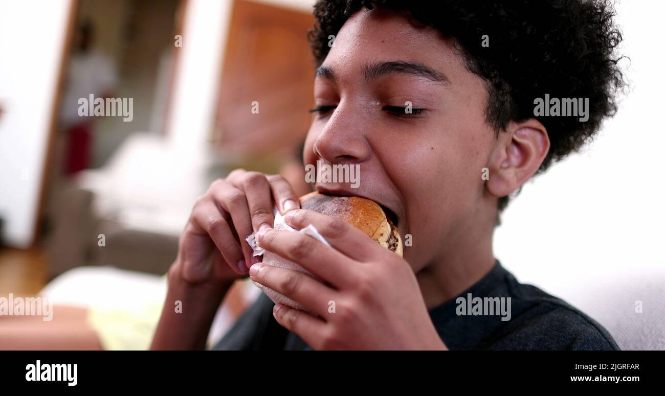 Child eating burger. Young boy taking a bite of hamburger Stock Photo ...