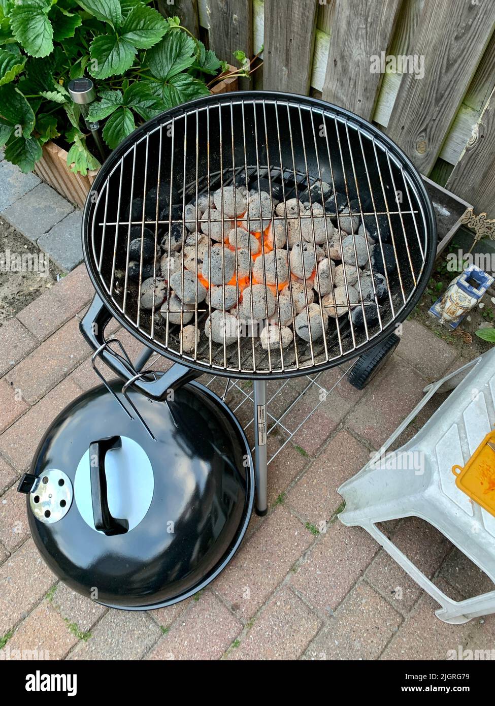 A vertical shot of lit hot coal briquettes in the black grill in the ...