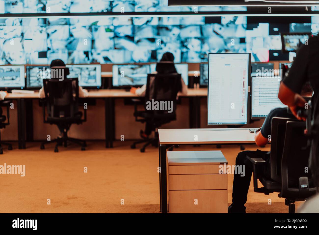 Male security operator working in a data system control room offices ...