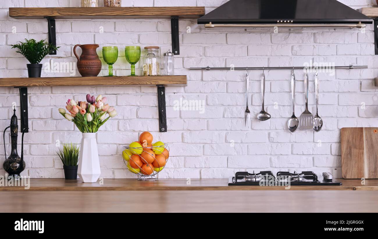 An interior design of cozy kitchen with white brick wall and range hod ...