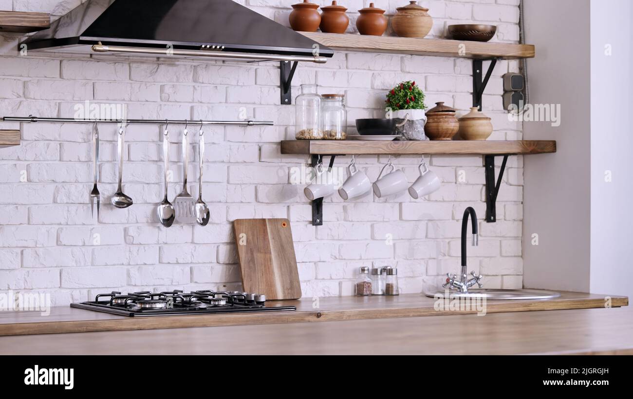 An interior design of cozy kitchen with white brick wall and range hod ...