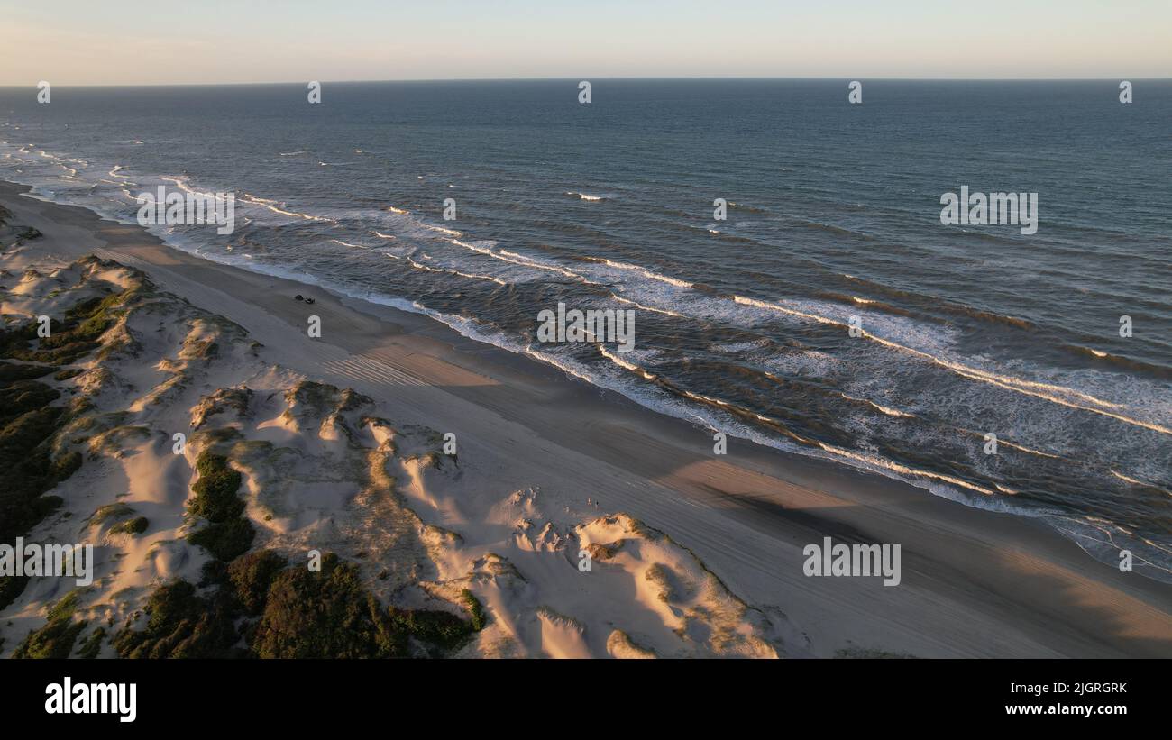 An aerial view of sea waves crashing into the sandy beach of Outer ...