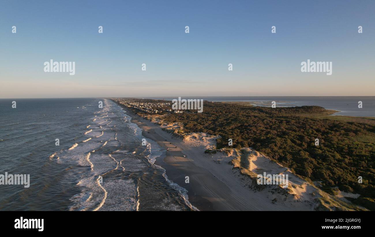 An aerial view of sea waves crashing into the sandy beach of Outer ...