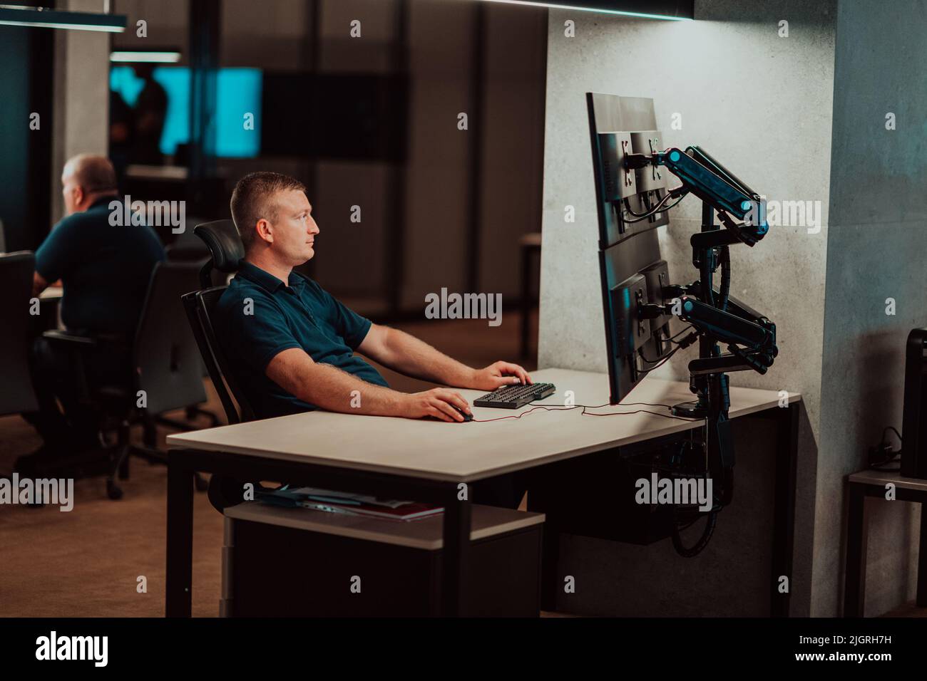 Male security operator working in a data system control room offices ...