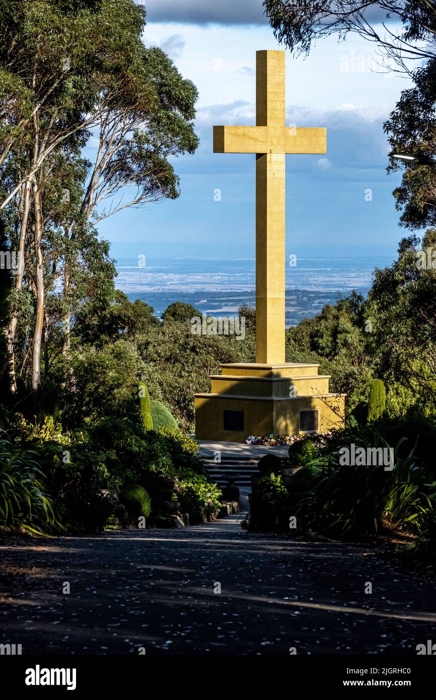 A vertical shot of the Mount Macedon Memorial Cross in a green park in ...