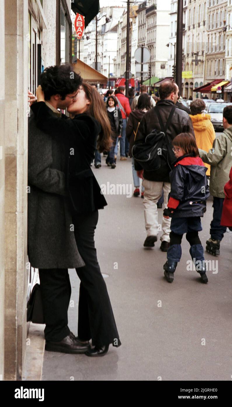 Oblivious of passersby, a young couple kiss on a public street in Paris, France Stock Photo - Alamy
