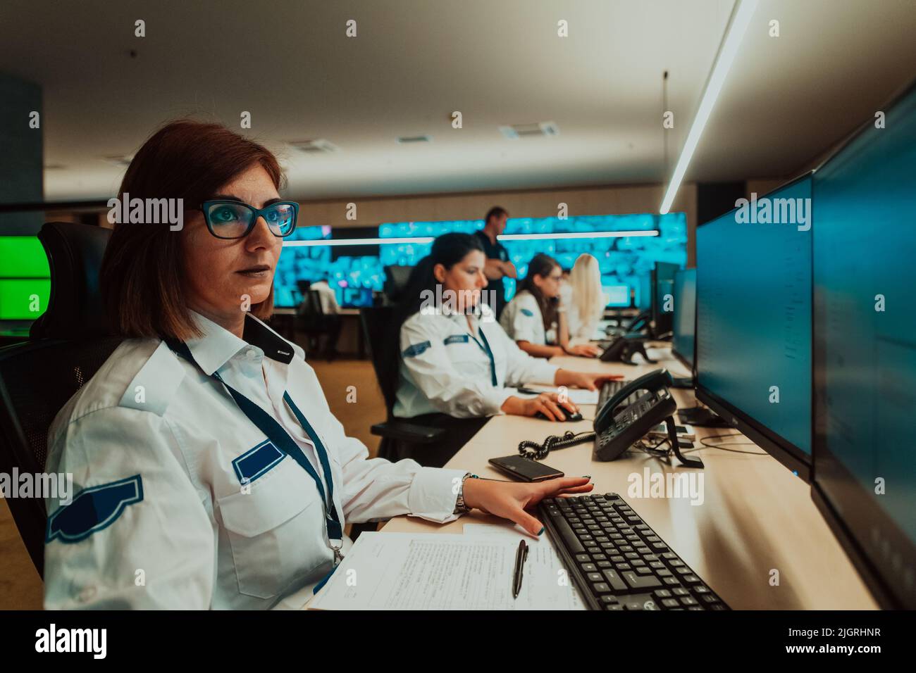 Group of female security operators working in a data system control ...