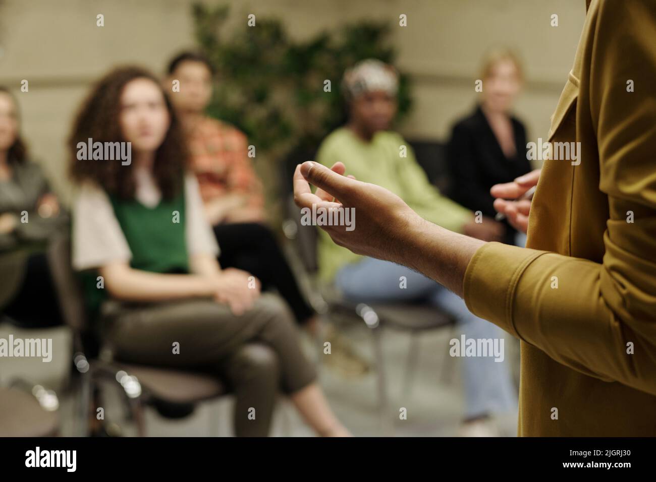 Hands of young business coach explaining information to group of ...
