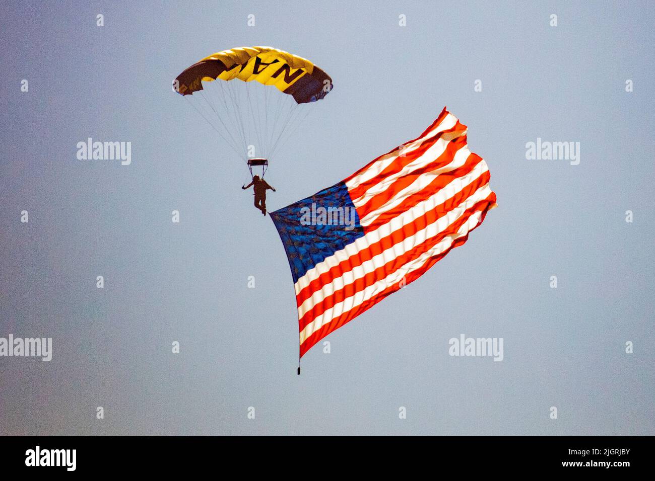 A member of the US Navy Leap Frogs Flag Jump unfurls a weighted US flag ...