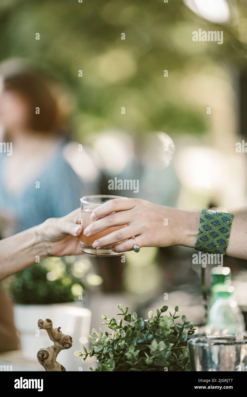 Woman handing over drink hi-res stock photography and images - Alamy