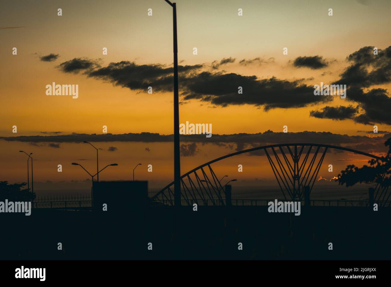 A breathtaking view of Bagatelle Bridge against orange cloudy sunset ...
