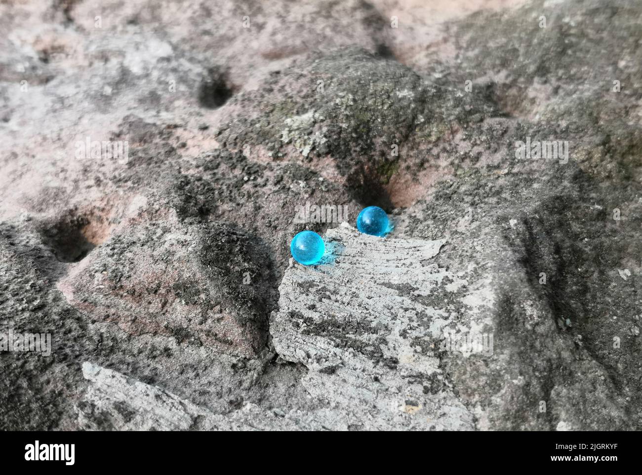 The two small blue balls on gray rock Stock Photo - Alamy