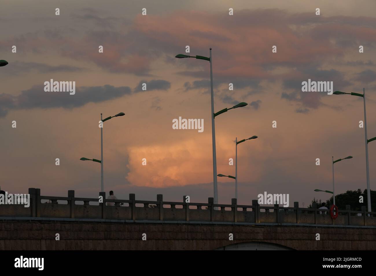 Beautiful sky with pink clouds behind tall streetlights Stock Photo - Alamy