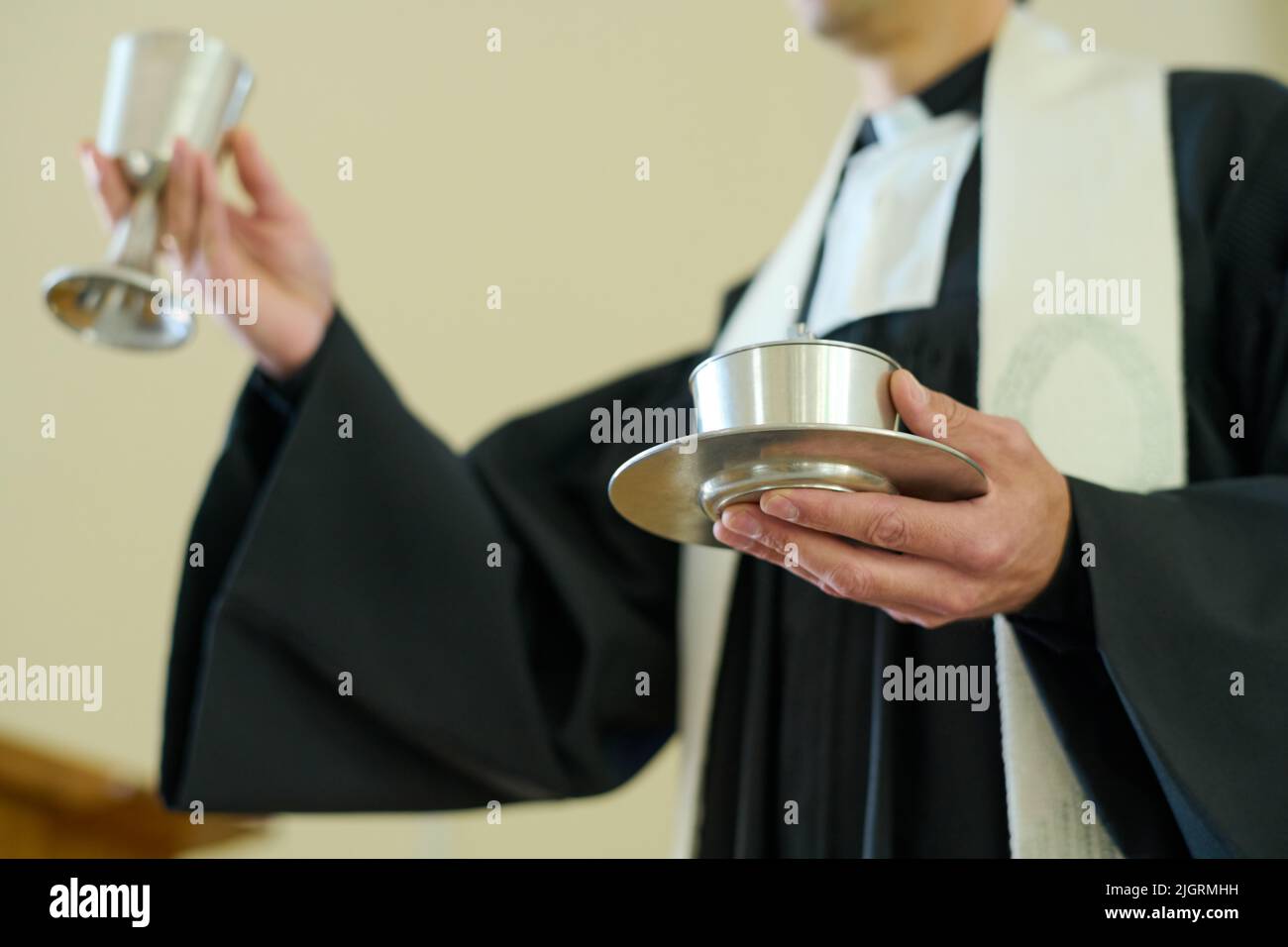 Catholic priest holding cups with wine and unleavened bread symbolizing ...