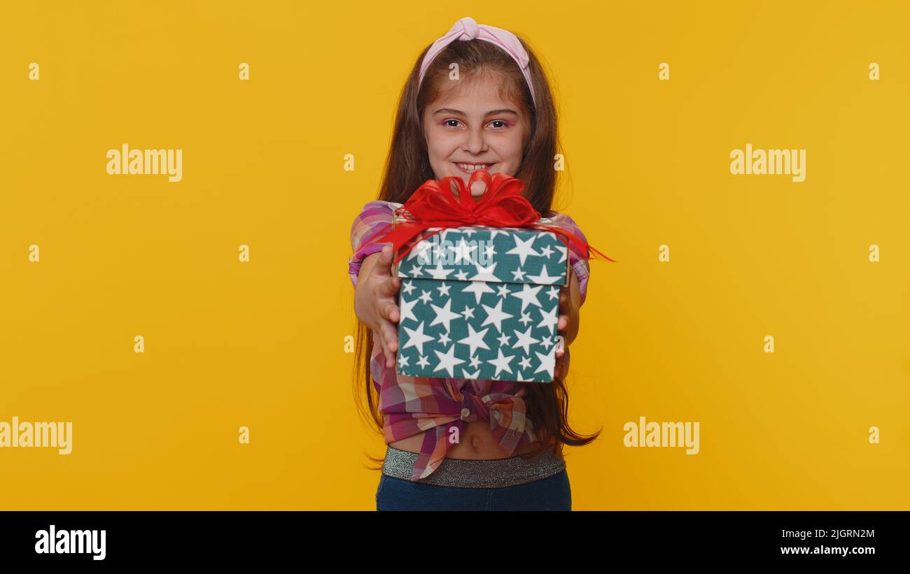 Lovely smiling young preteen child girl kid presenting birthday gift ...