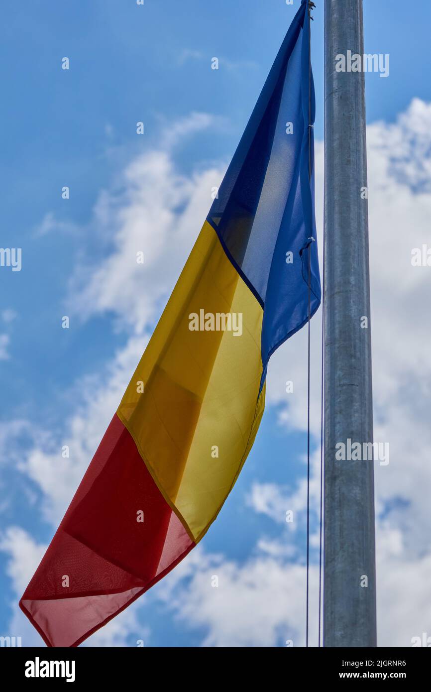 The romanian flag in the wind with blue sky with clouds Stock Photo - Alamy