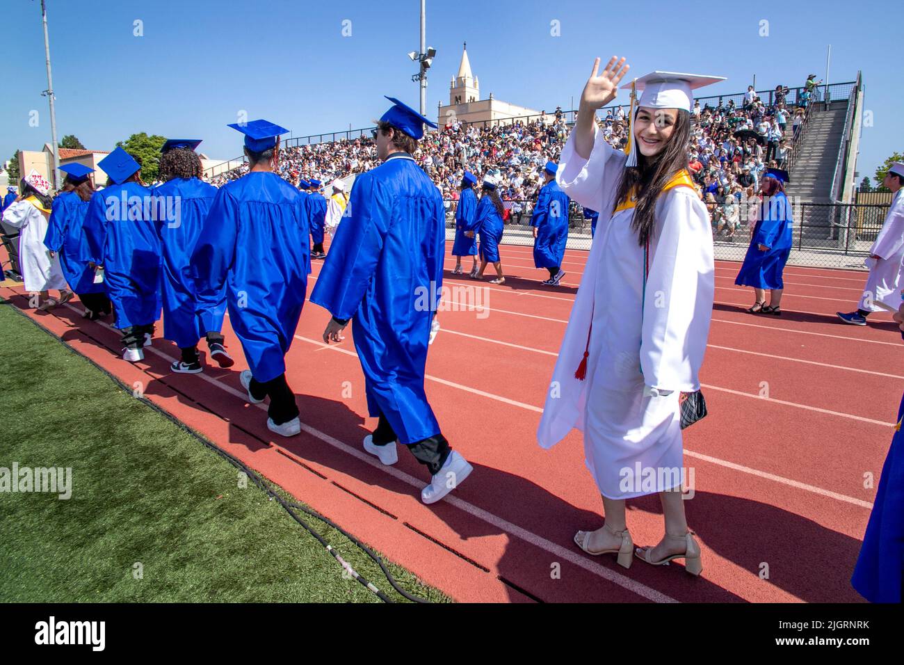 Wearing a white National Honor Society cap and gown, a smiling high ...