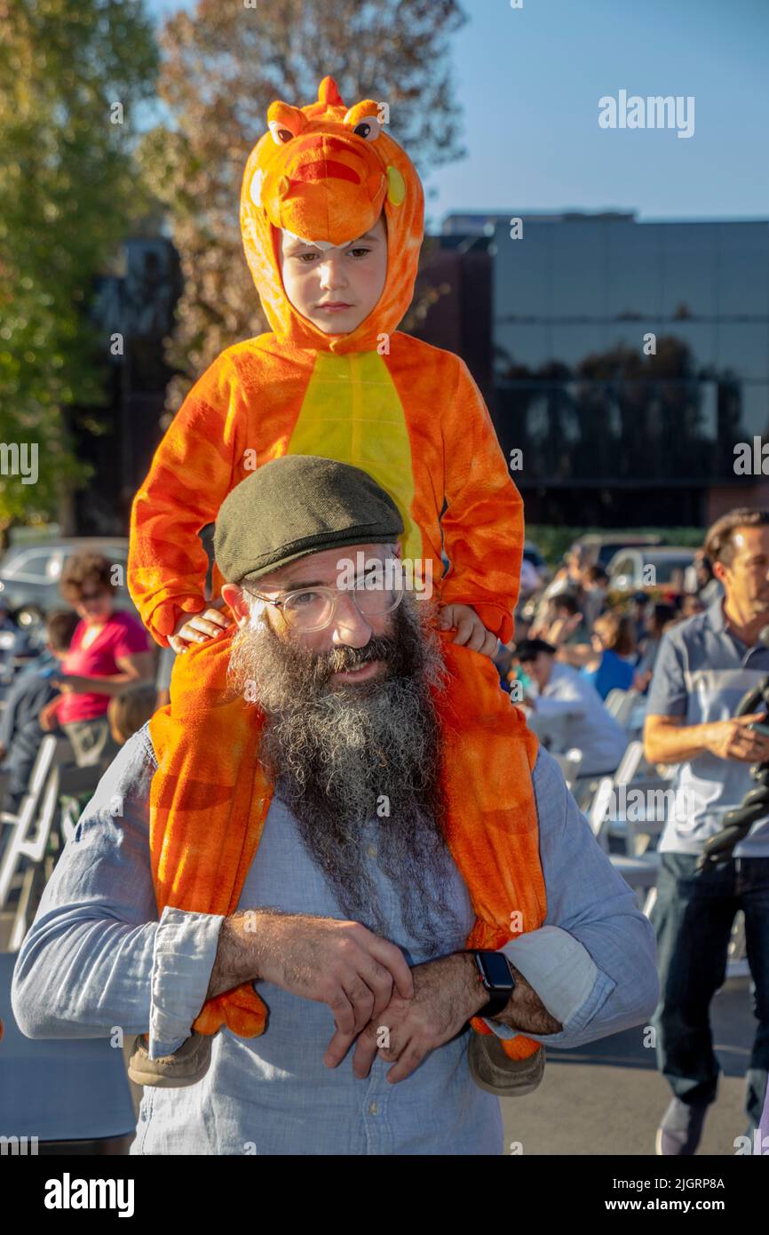 An orthodox Jewish father's son is dressed in a dragon costume at an ...