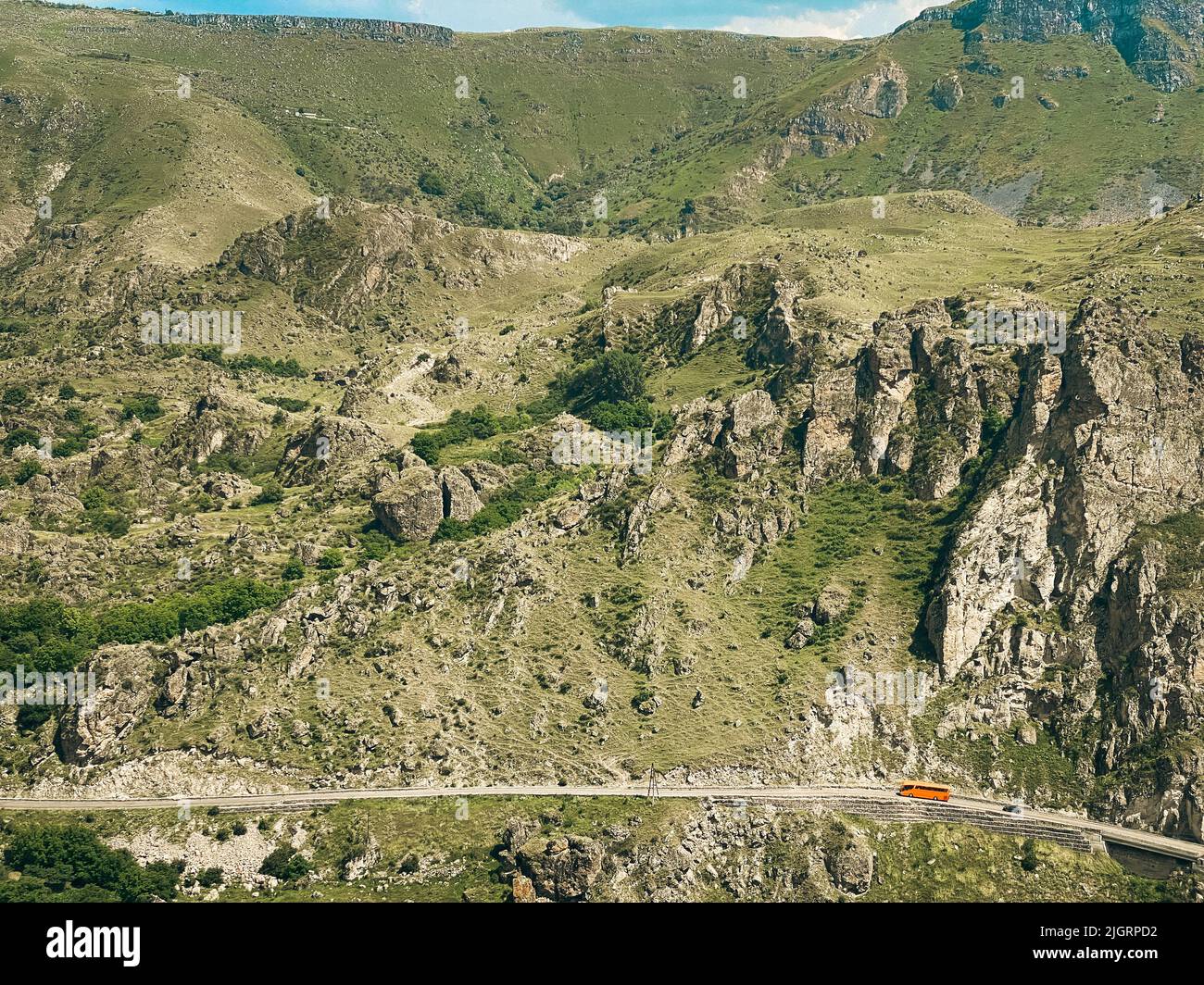 Aerial view orange tour bus drive on highway from Vardzia city in ...