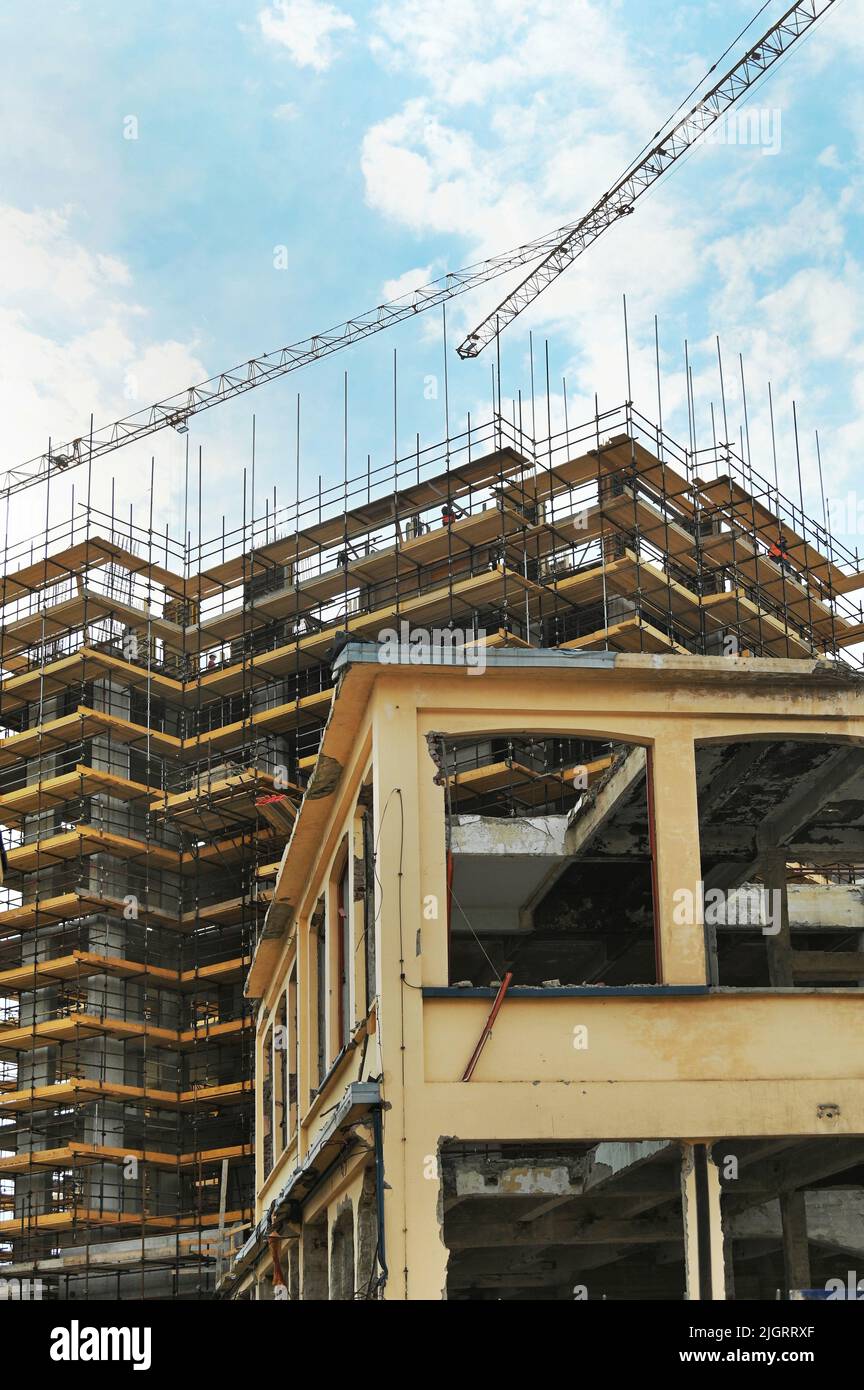 A vertical shot of a construction site with huge scaffolding and cranes ...