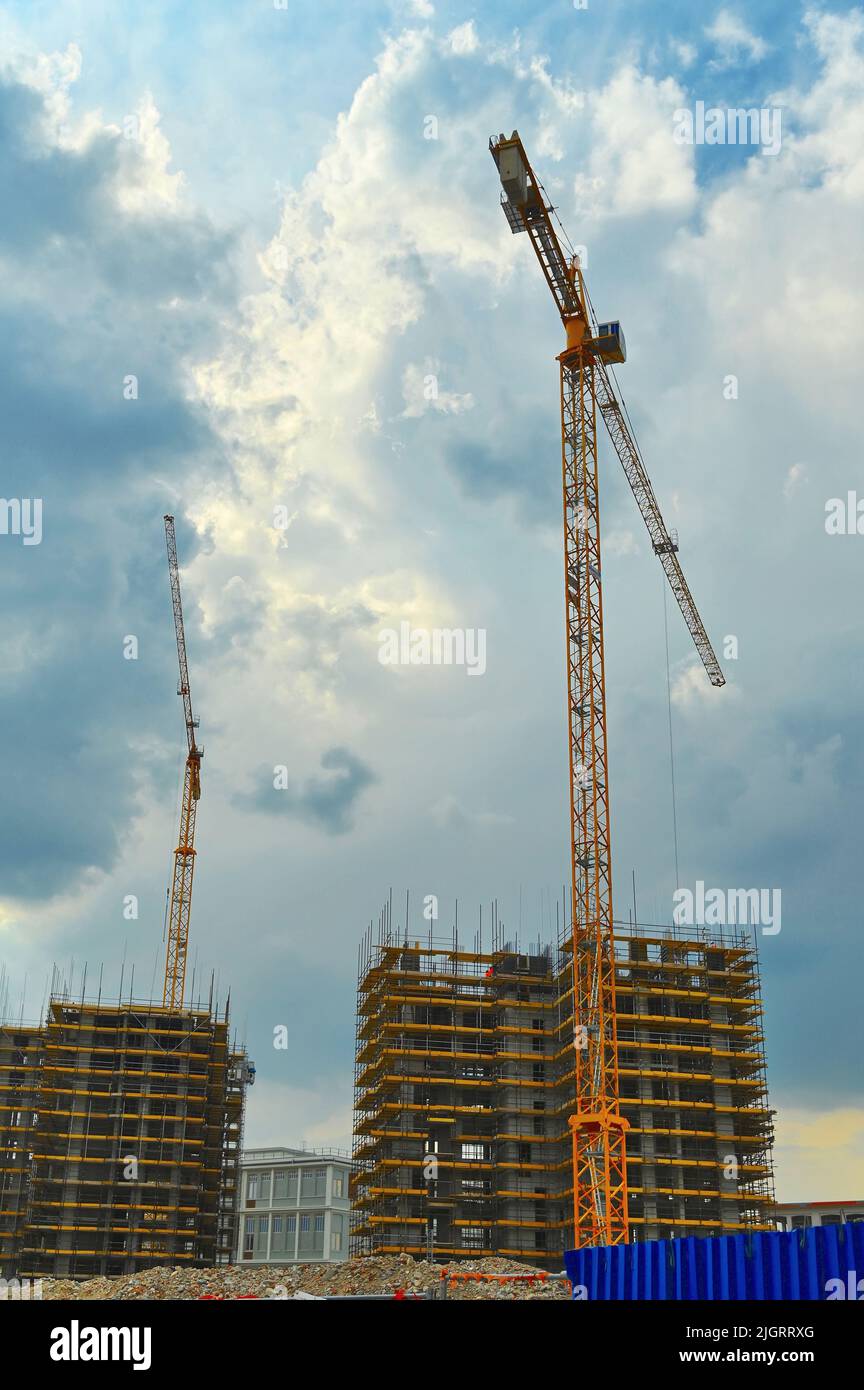 A vertical shot of a construction site with huge scaffolding and cranes ...