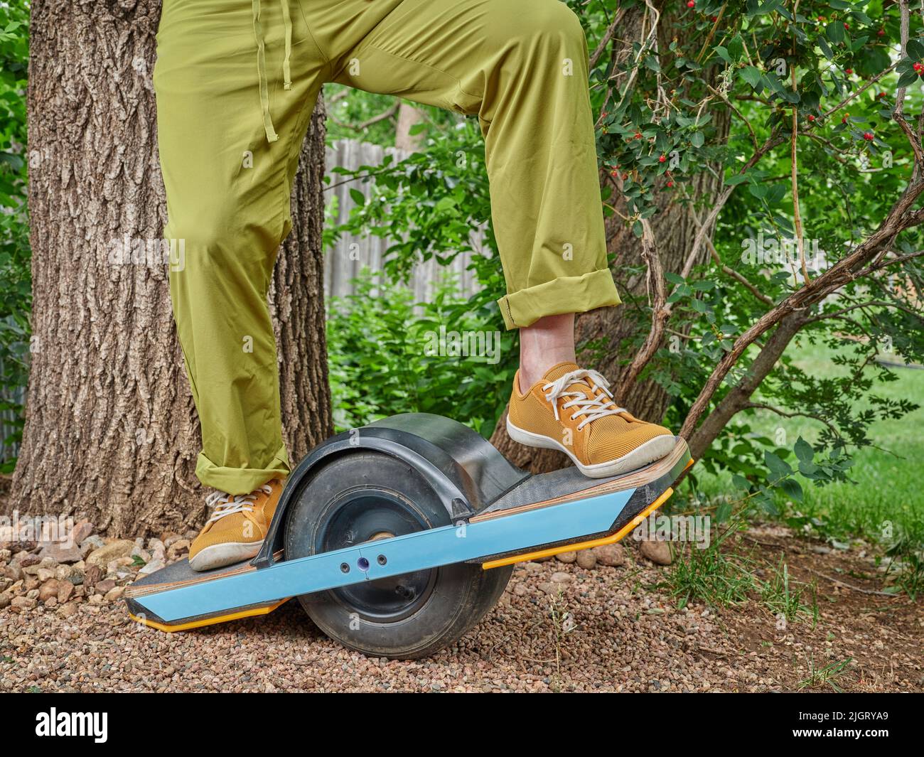 riding one-wheeled electric skateboard in a backyard or park Stock ...