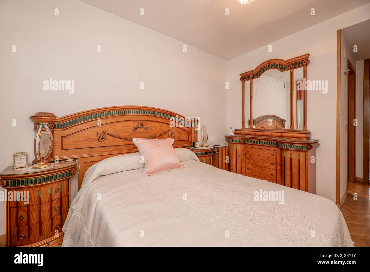 Bedroom with double bed with tacky wooden headboard in a room with oak ...