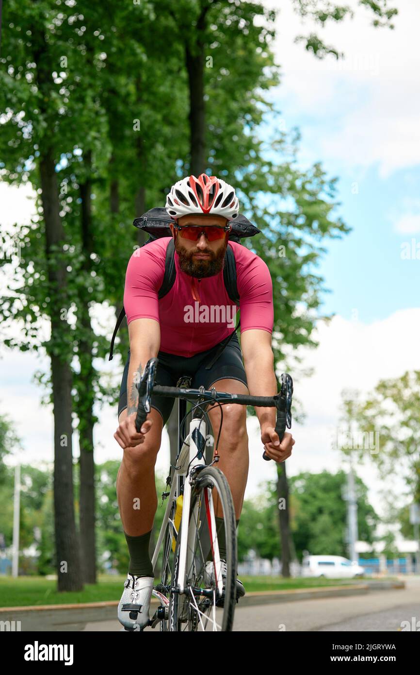 Strong Male cyclist in sportswear, glasses and protective helmet ...
