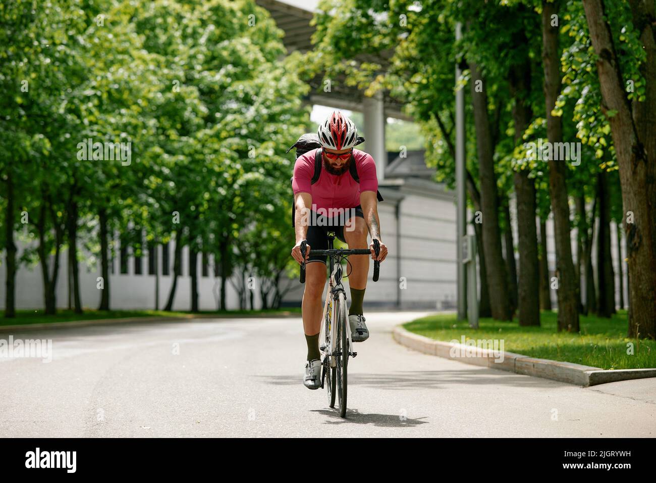 Strong Male cyclist in sportswear, glasses and protective helmet ...