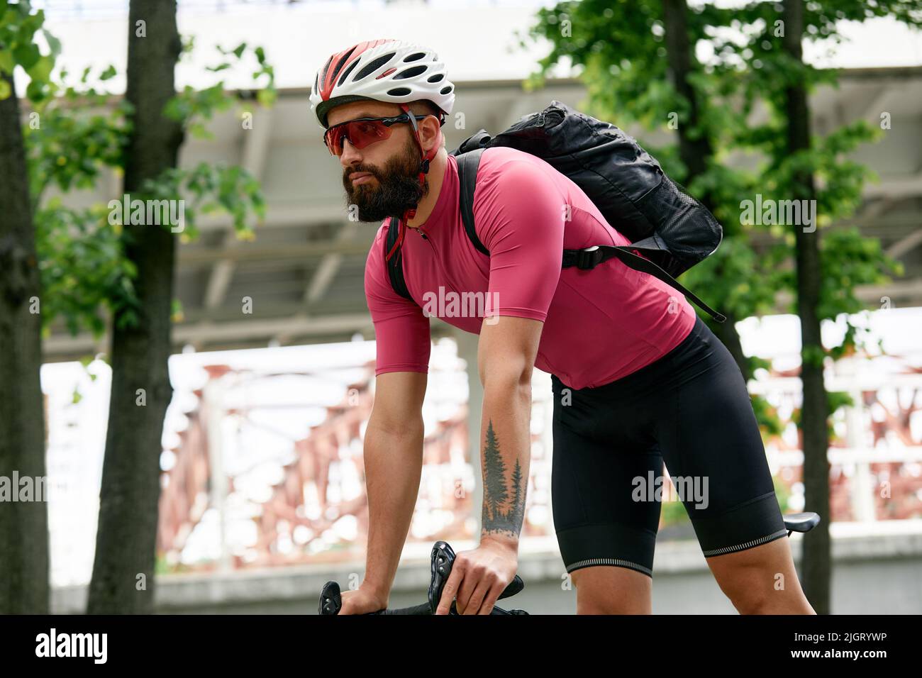 Strong Male cyclist in sportswear, glasses and protective helmet ...