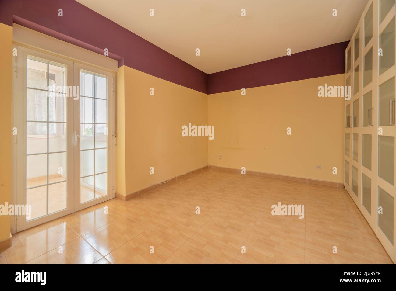 Empty room with access to a terrace with white aluminum and glass doors ...
