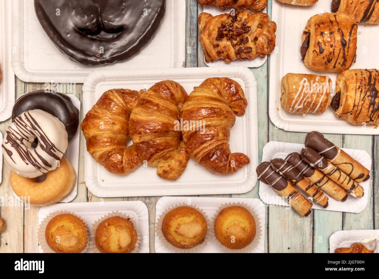Set of freshly baked sweet products, chocolate palms, assorted donuts ...