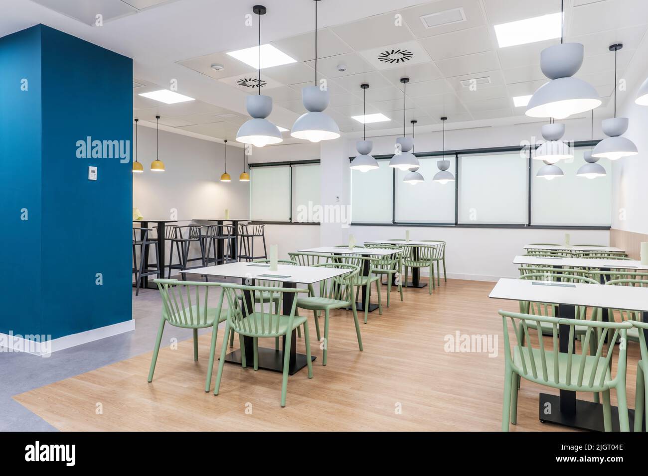 common dining room of a coworking office building with gray tables and ...