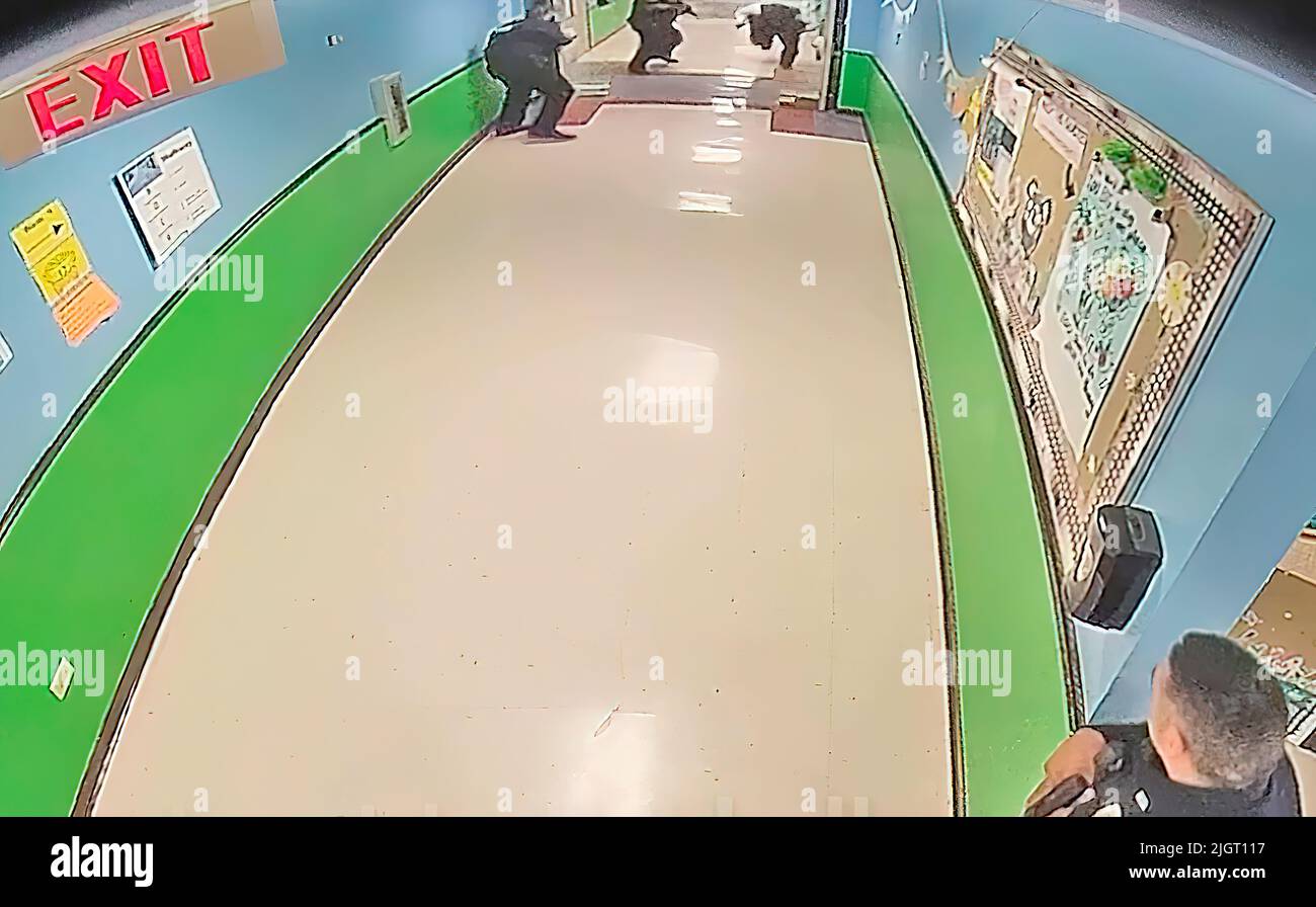 A frame from a school surveillance video shows multiple police officers ...