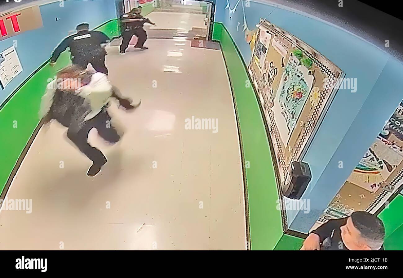 A frame from a school surveillance video shows multiple police officers ...