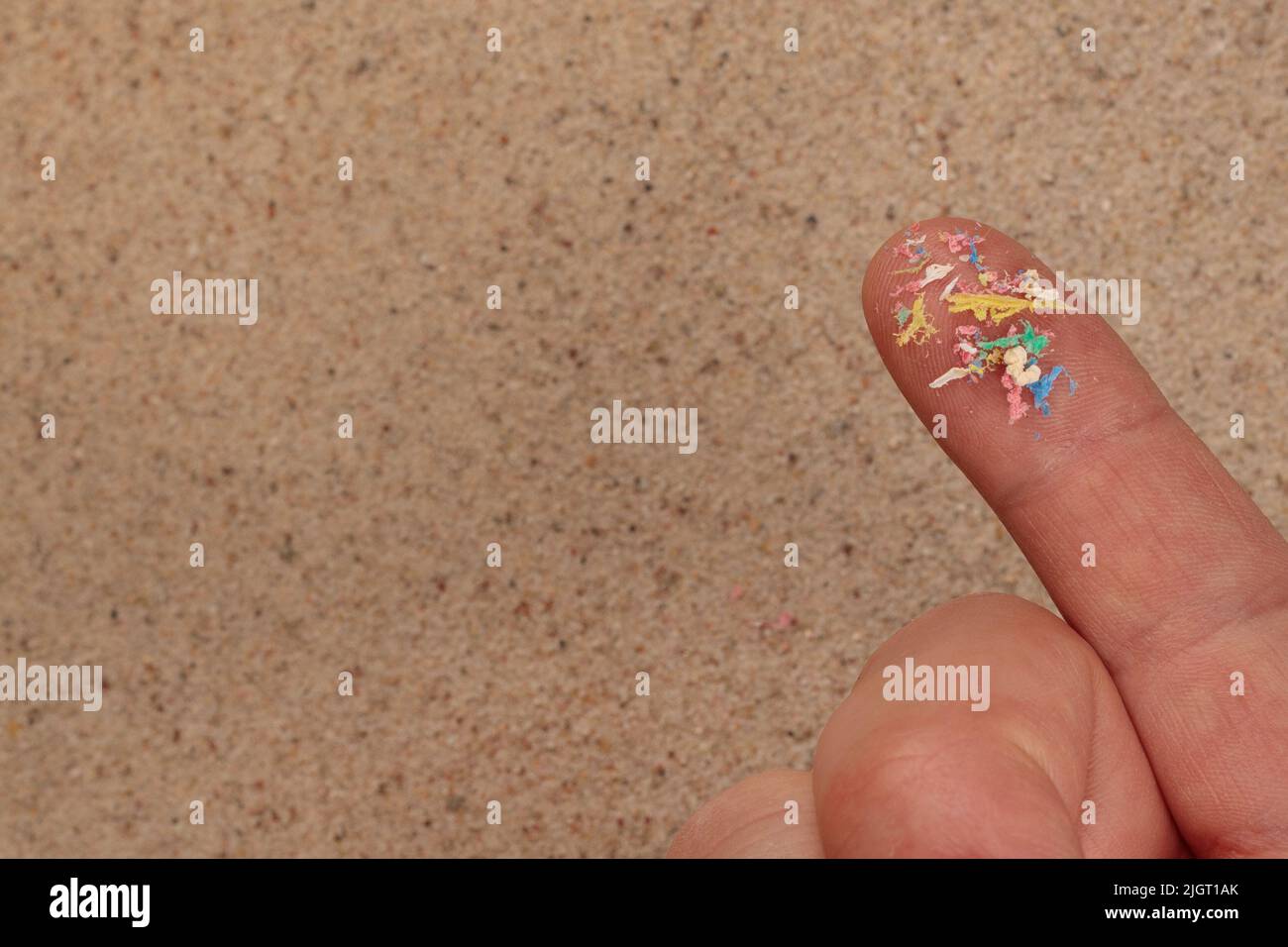 Fragments of microplastic on the finger of the hand, top view on the ...