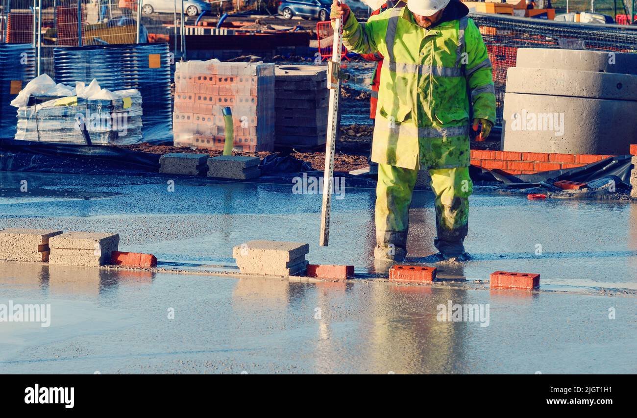 Builder pouring ground floor slab of new house with wet ready-mix ...